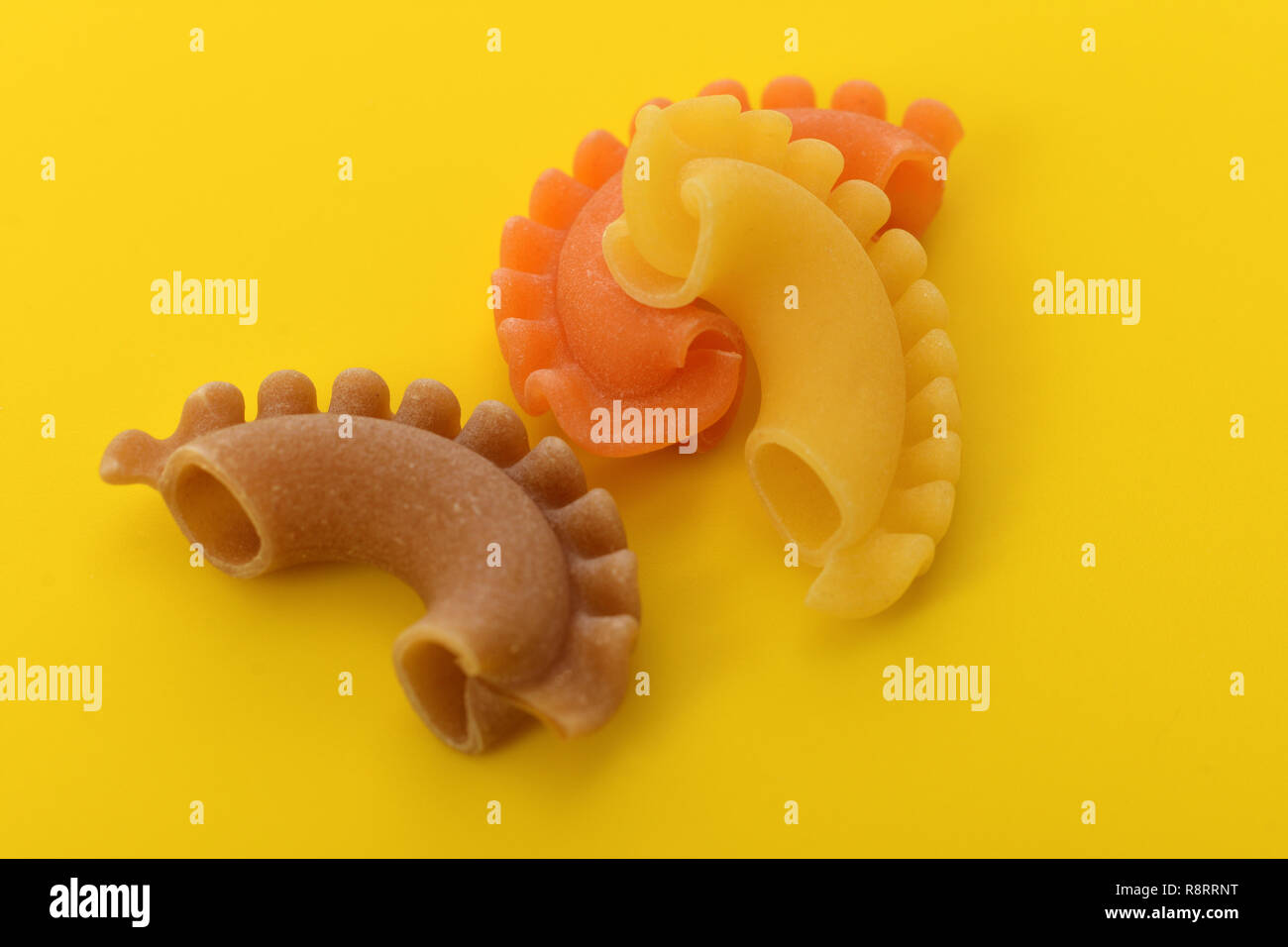Pasta creste di gallo on yellow background Stock Photo - Alamy