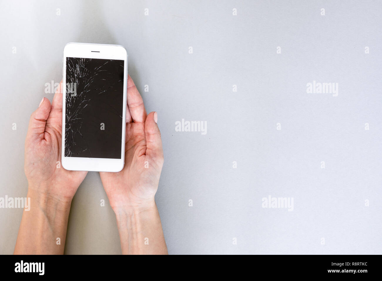 Smartphone with broken screen in hand on grey background Stock Photo ...