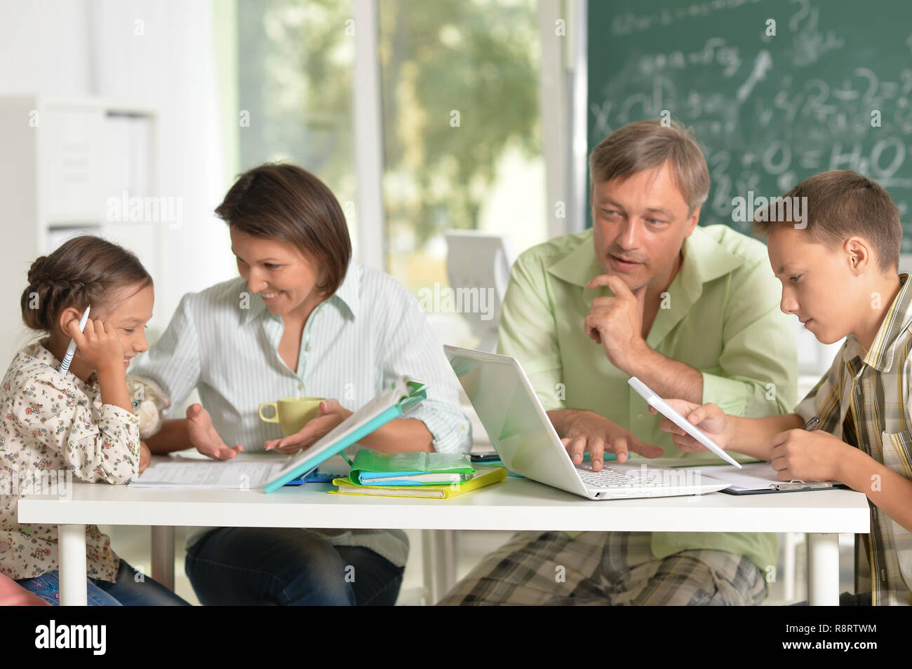 Portrait of parents helping their children to do their homework in the ...