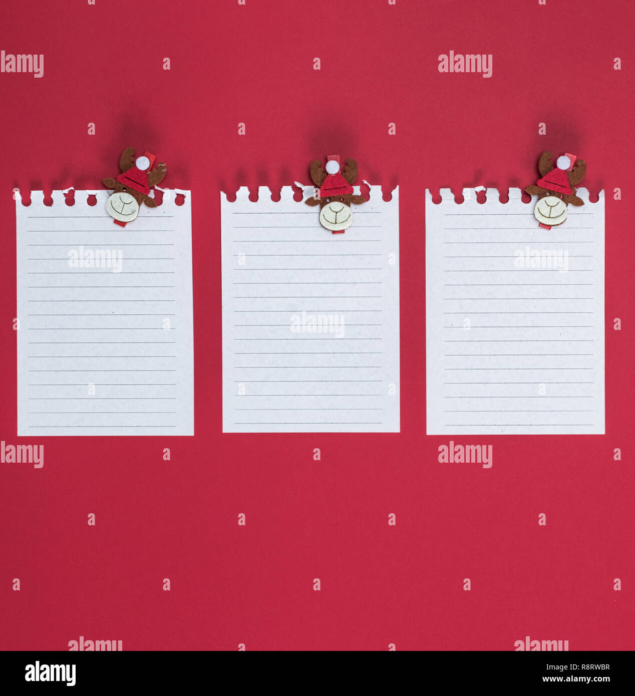 white blank sheet in a line torn out of notepad on a red background ...