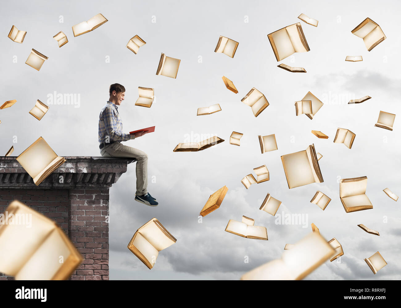Man reading book and many of them flying in air Stock Photo - Alamy