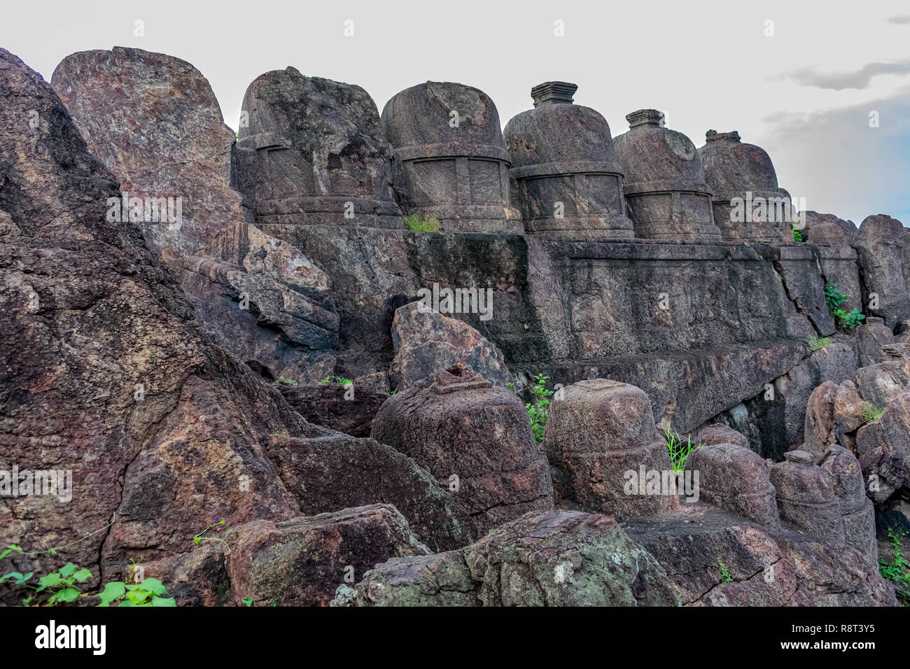 big circular rock shaped vertical located close top front & side view ...