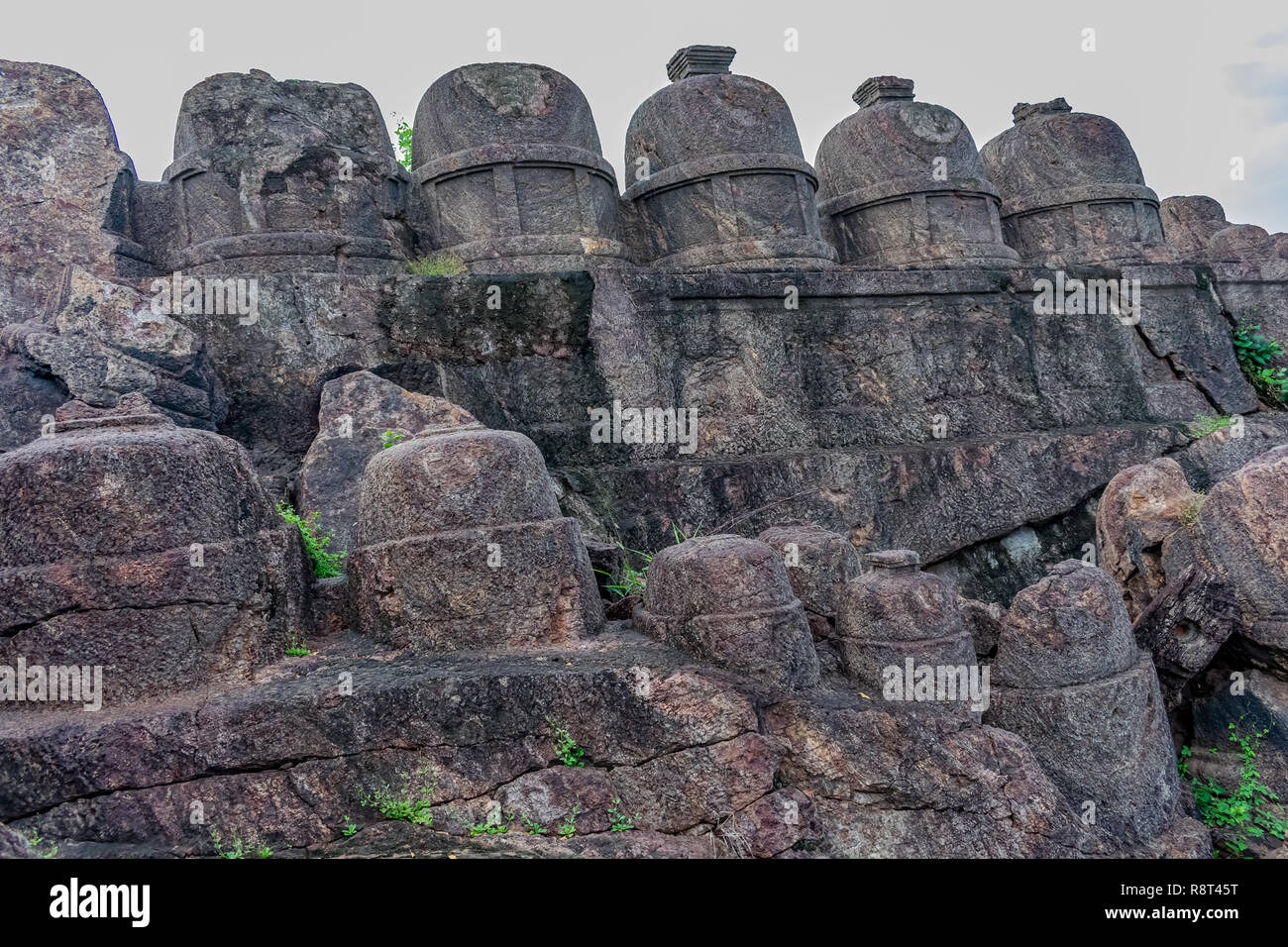 big circular rock shaped vertical located close top front & side view ...