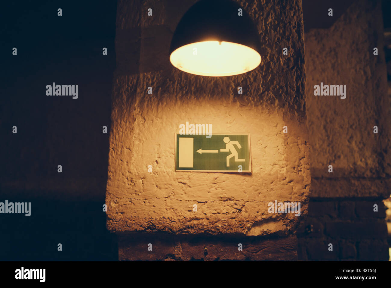 Emergency fire escape sign on the empty wall Stock Photo - Alamy