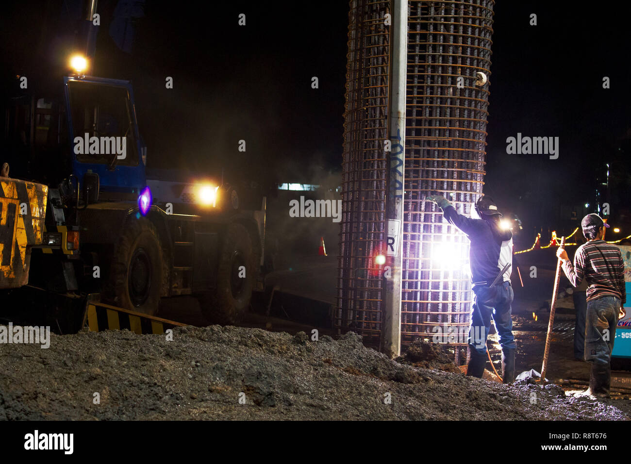 two manual laborers are completing work at night Stock Photo - Alamy