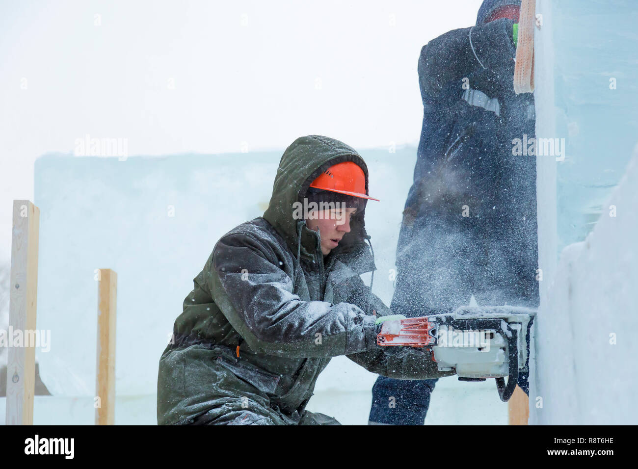 Construction worker saws an ice plate with a chainsaw Stock Photo - Alamy