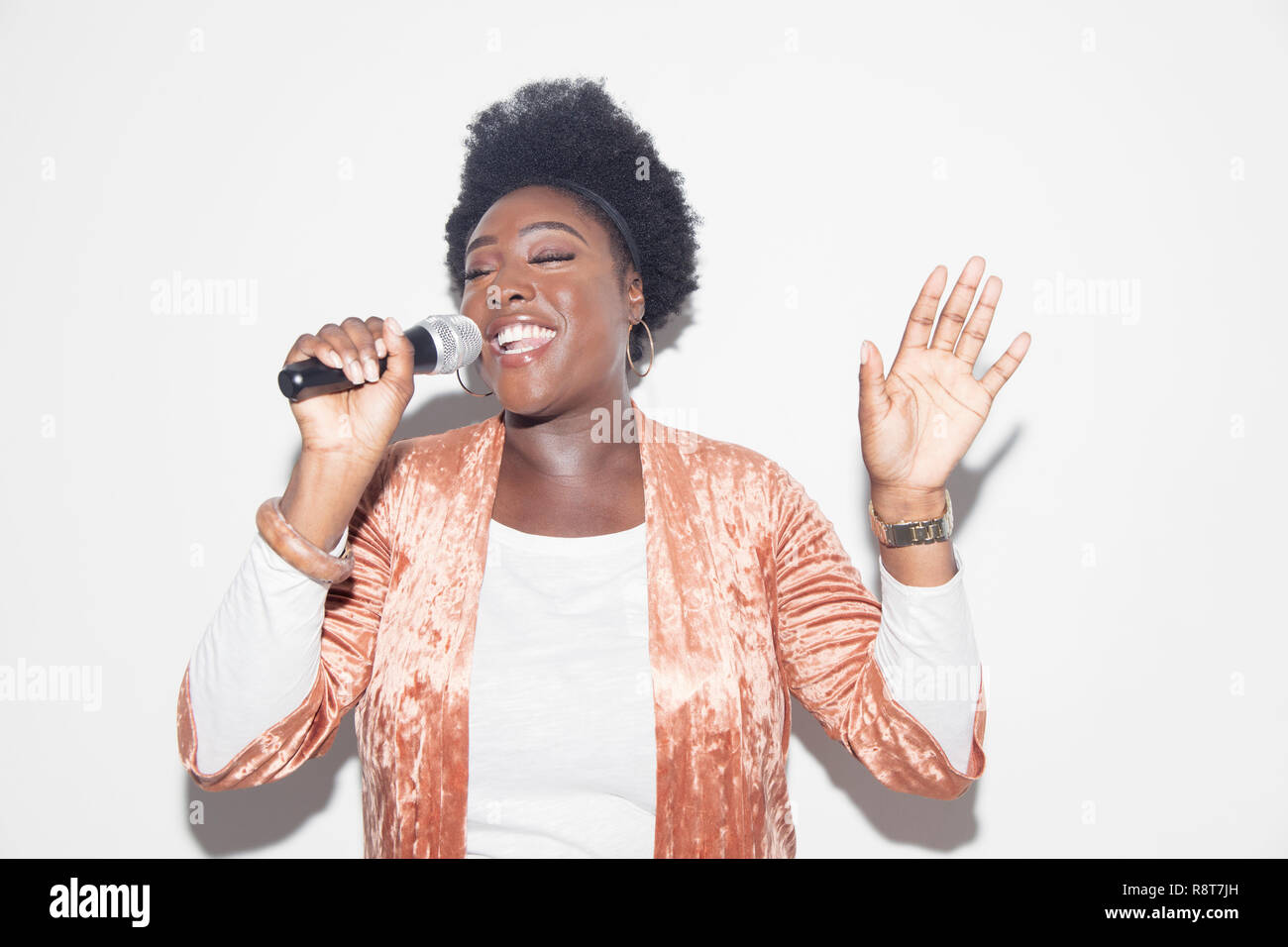 Woman singing with microphone Stock Photo - Alamy