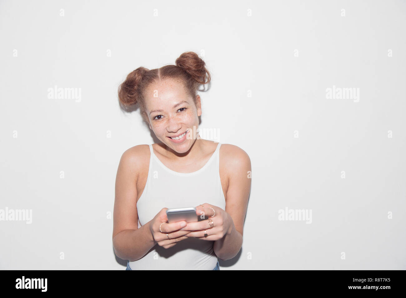 Portrait smiling, confident young woman texting with smart phone Stock ...