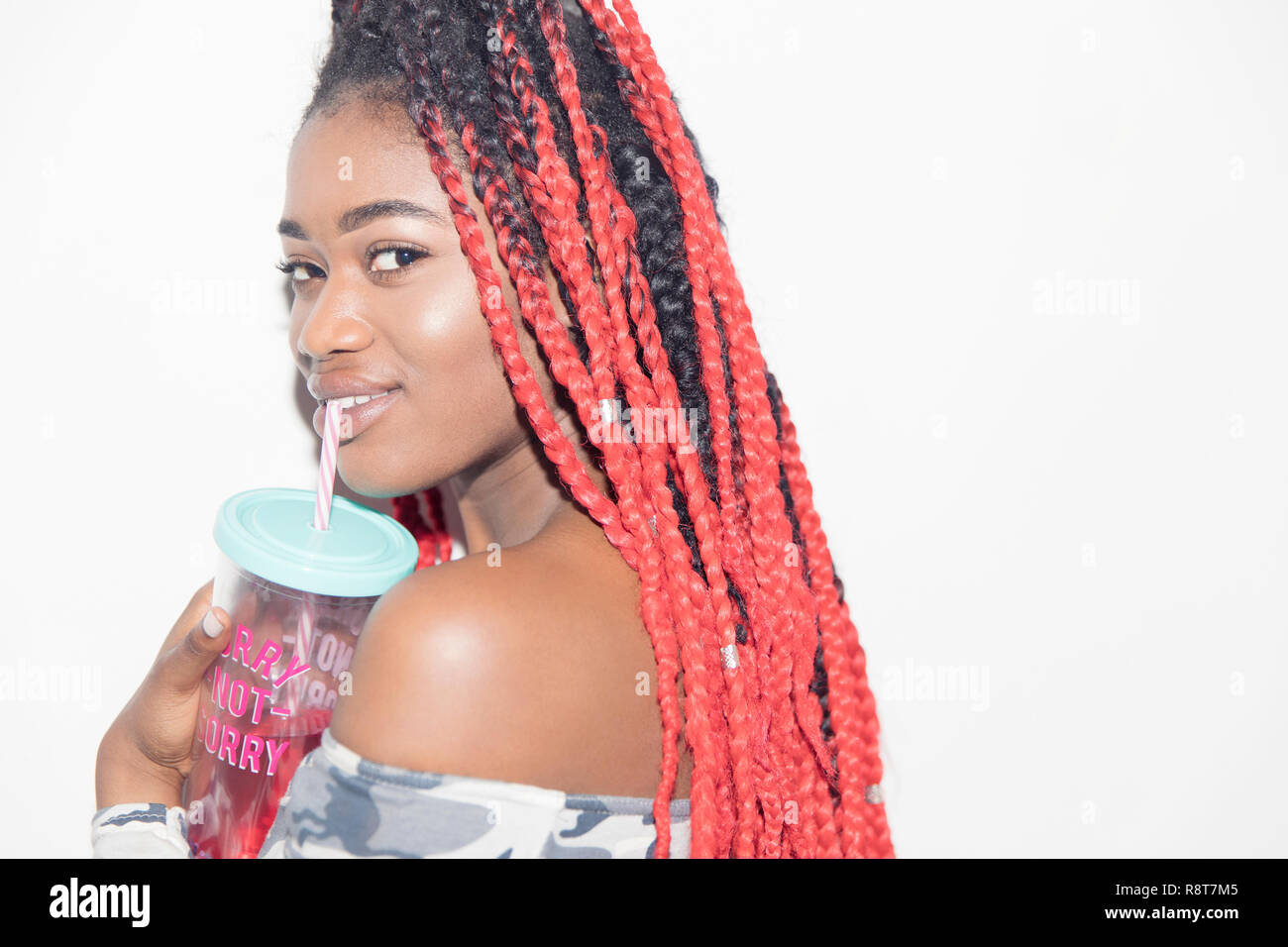 Portrait smiling, confident young woman with long braids drinking juice ... Portrait smiling, confident young woman with long braids drinking juice ...