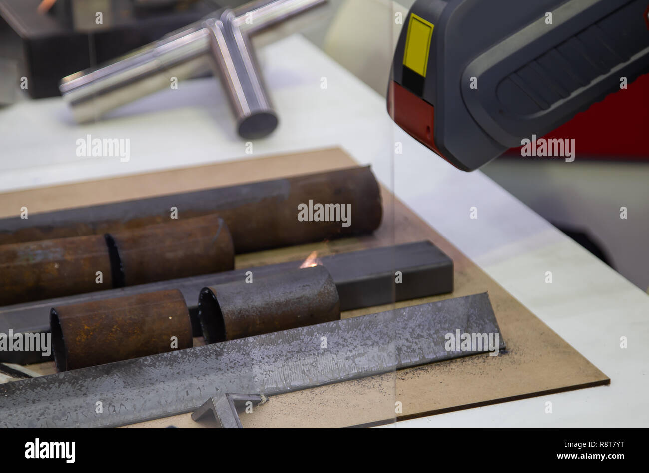 Handheld laser cleaning gun removing rust from tube Stock Photo - Alamy
