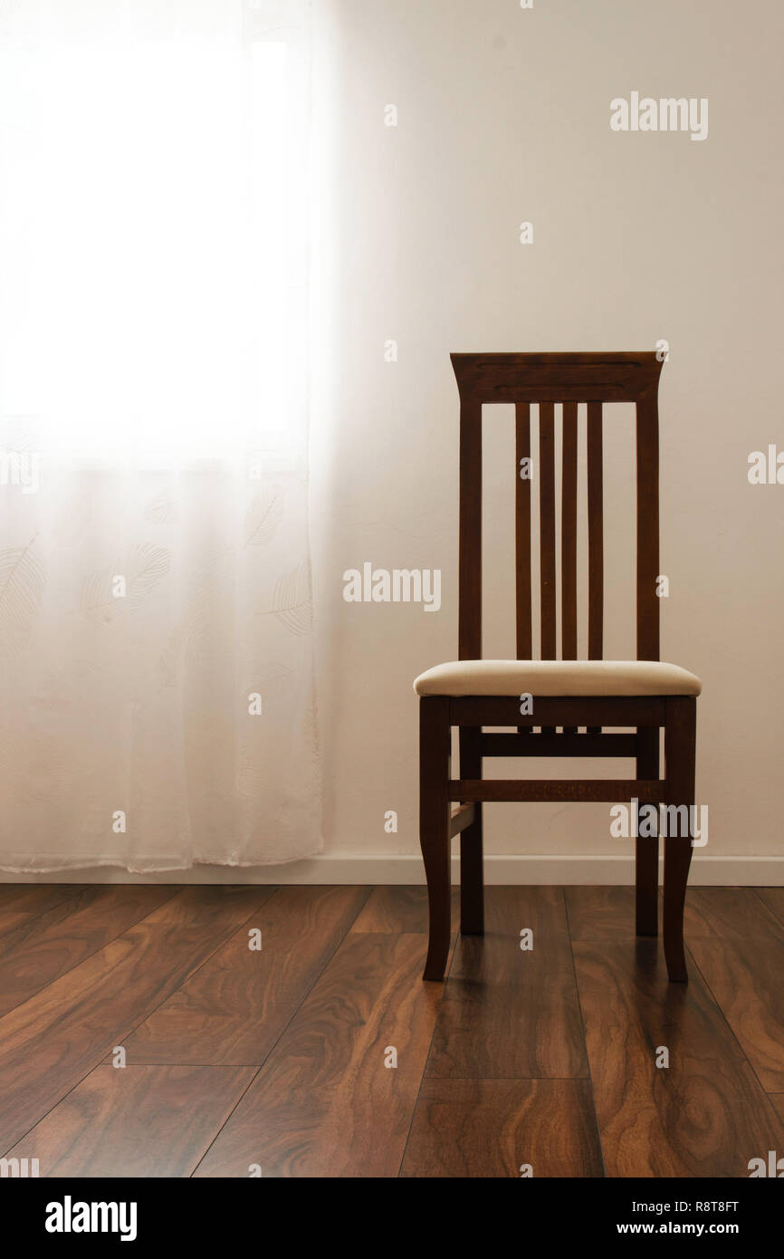 One isolated wooden chair in an empty living room Stock Photo - Alamy