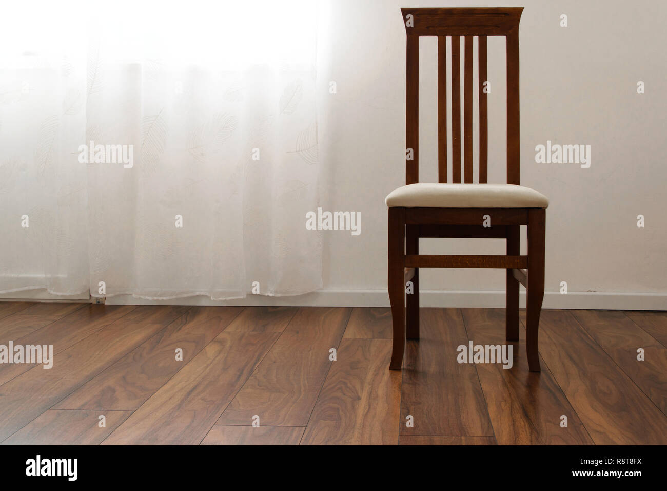 One isolated wooden chair in an empty living room Stock Photo - Alamy