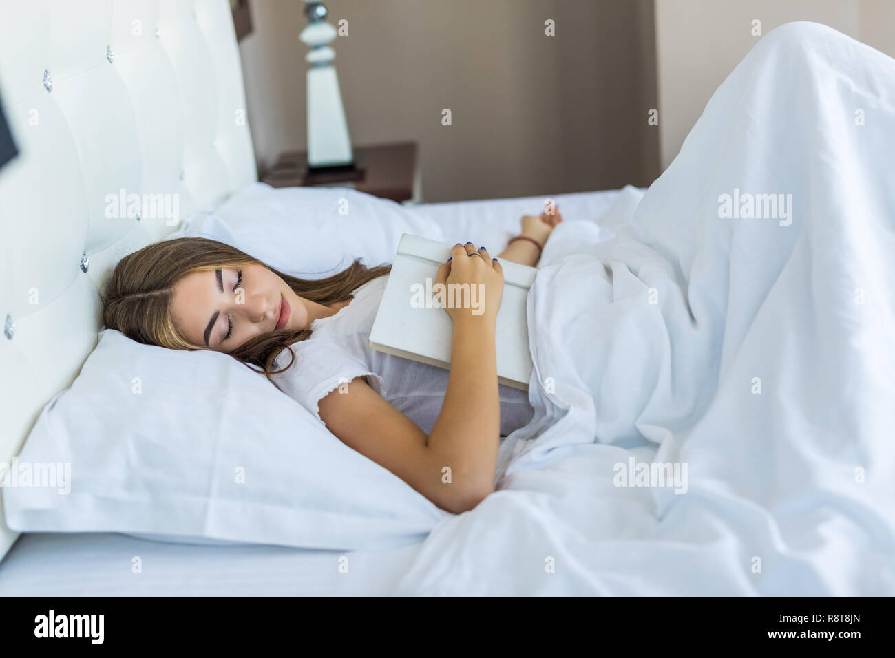 Beautiful woman falling asleep while reading a book Stock Photo - Alamy