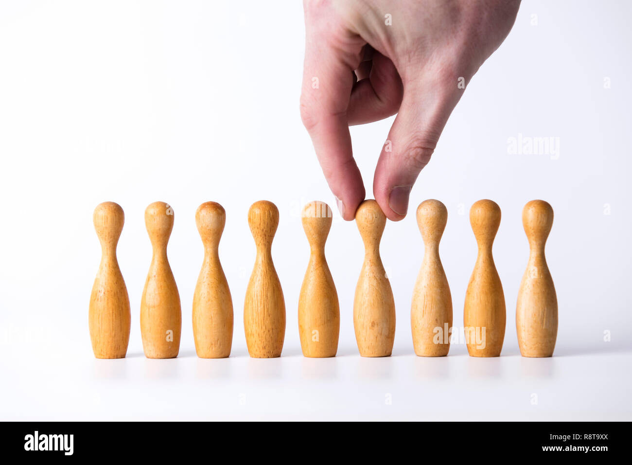 Hand selecting a wooden figure. Business leadership concept Stock Photo ...