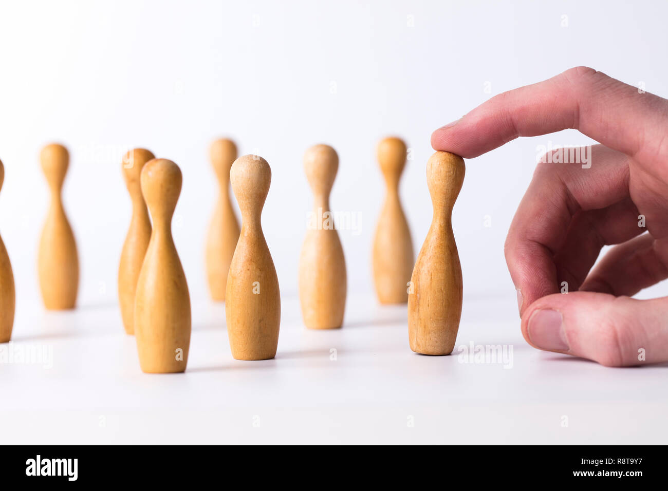 Hand selecting a wooden figure. Business leadership concept Stock Photo ...