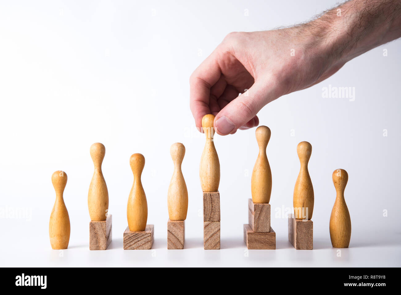 Hand selecting a wooden figure. Business leadership concept Stock Photo ...