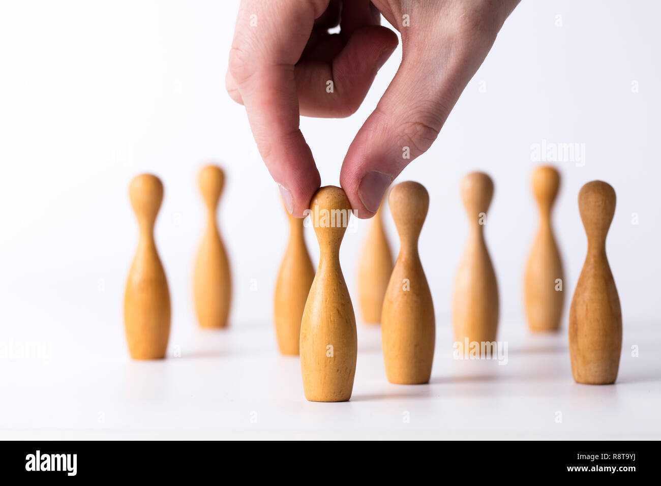 Hand selecting a wooden figure. Business leadership concept Stock Photo ...