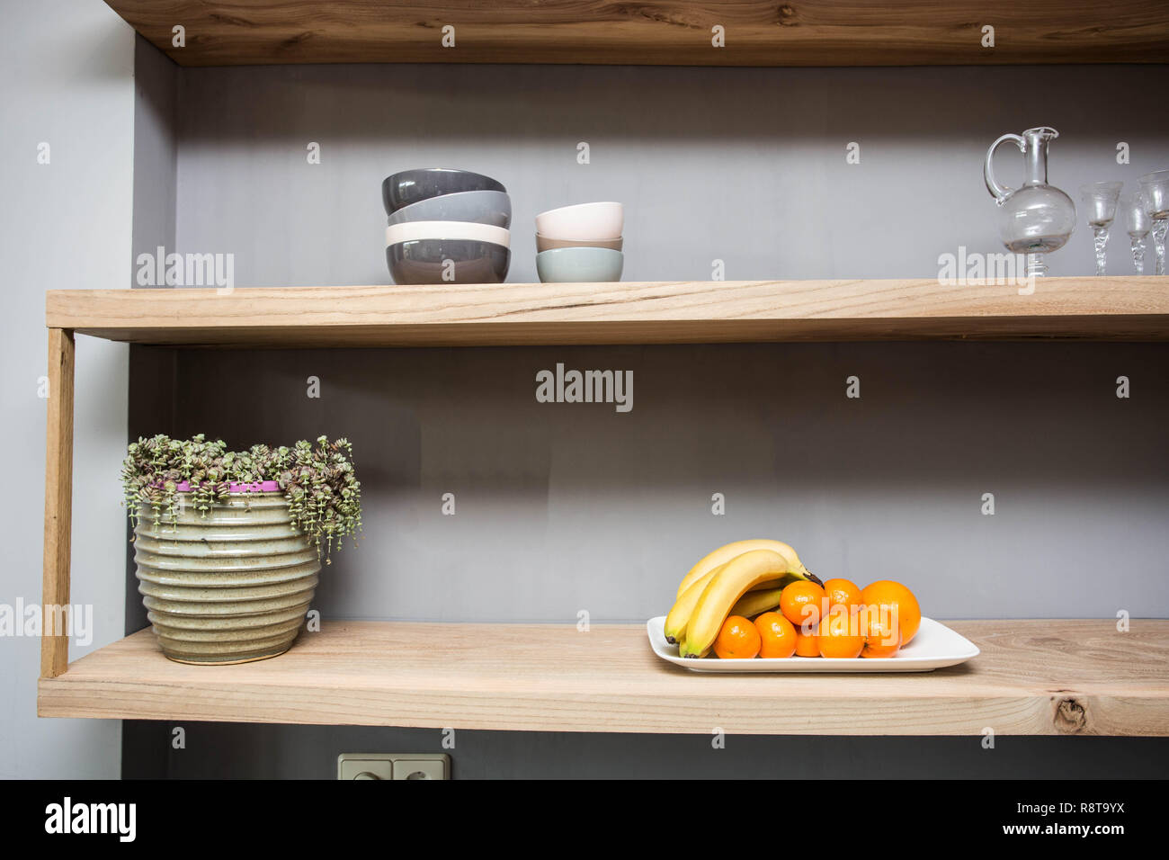 Shelf with various things and fruits on the table, green plant and ...