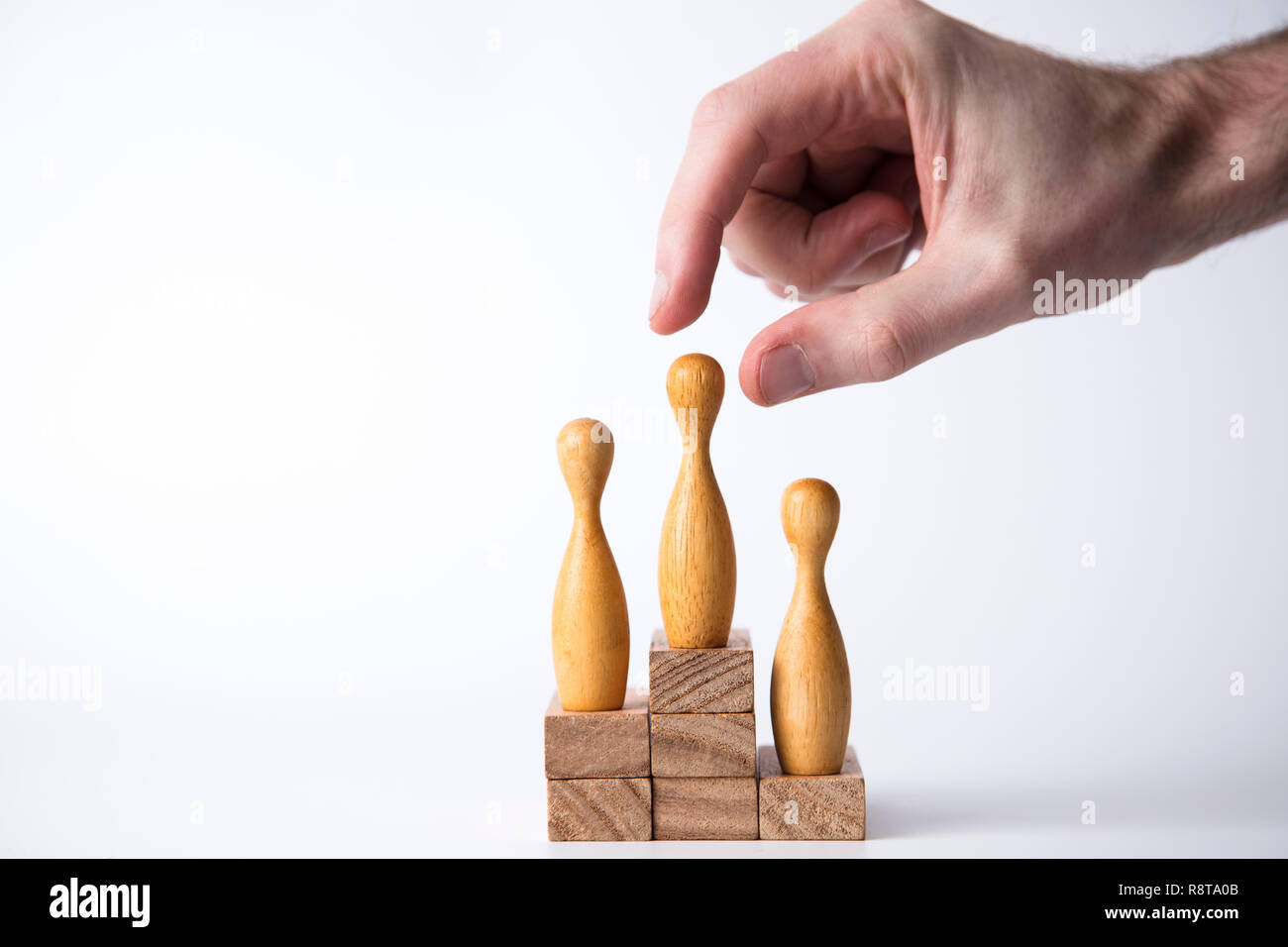 Hand selecting a wooden figure. Business leadership concept Stock Photo ...