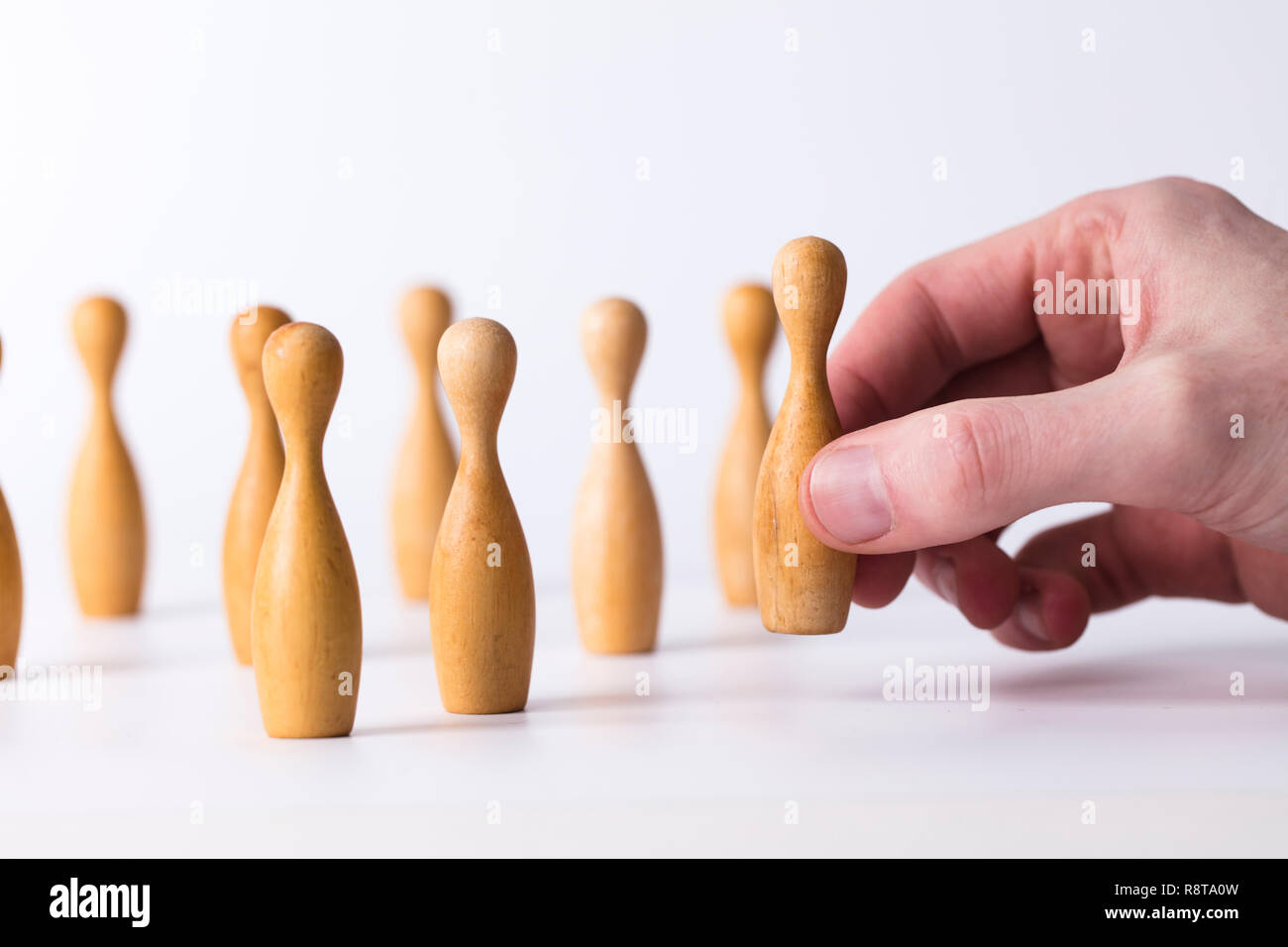 Hand selecting a wooden figure. Business leadership concept Stock Photo ...