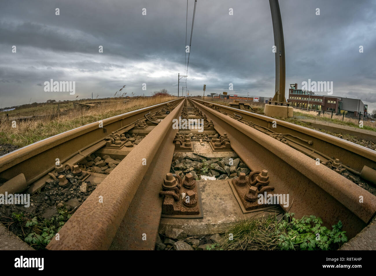 Wide angle view of a rusty railroad leading into the distance ...