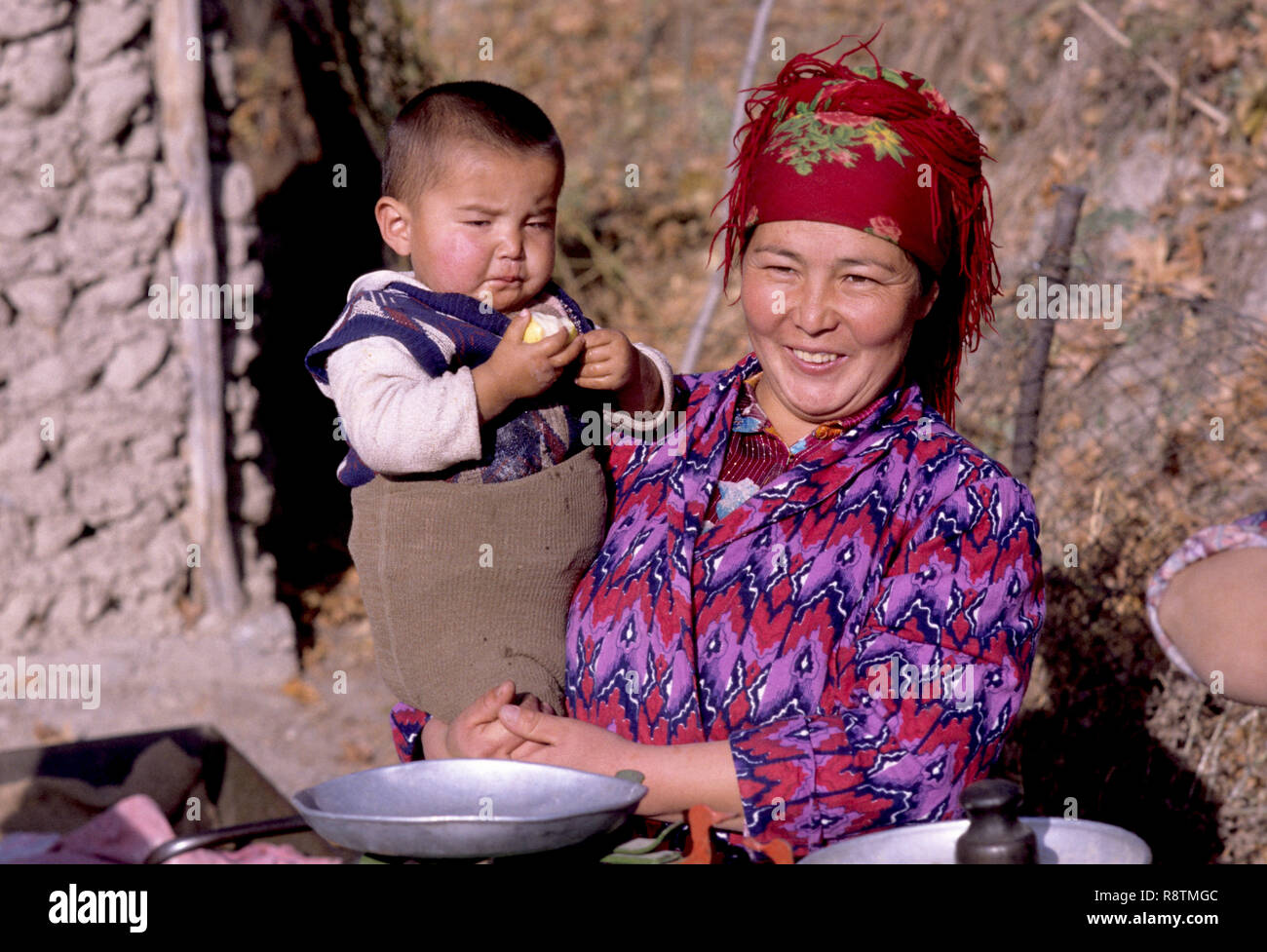 Smiling, an Uzbek woman at her stall in the market of Khiva holds her ...