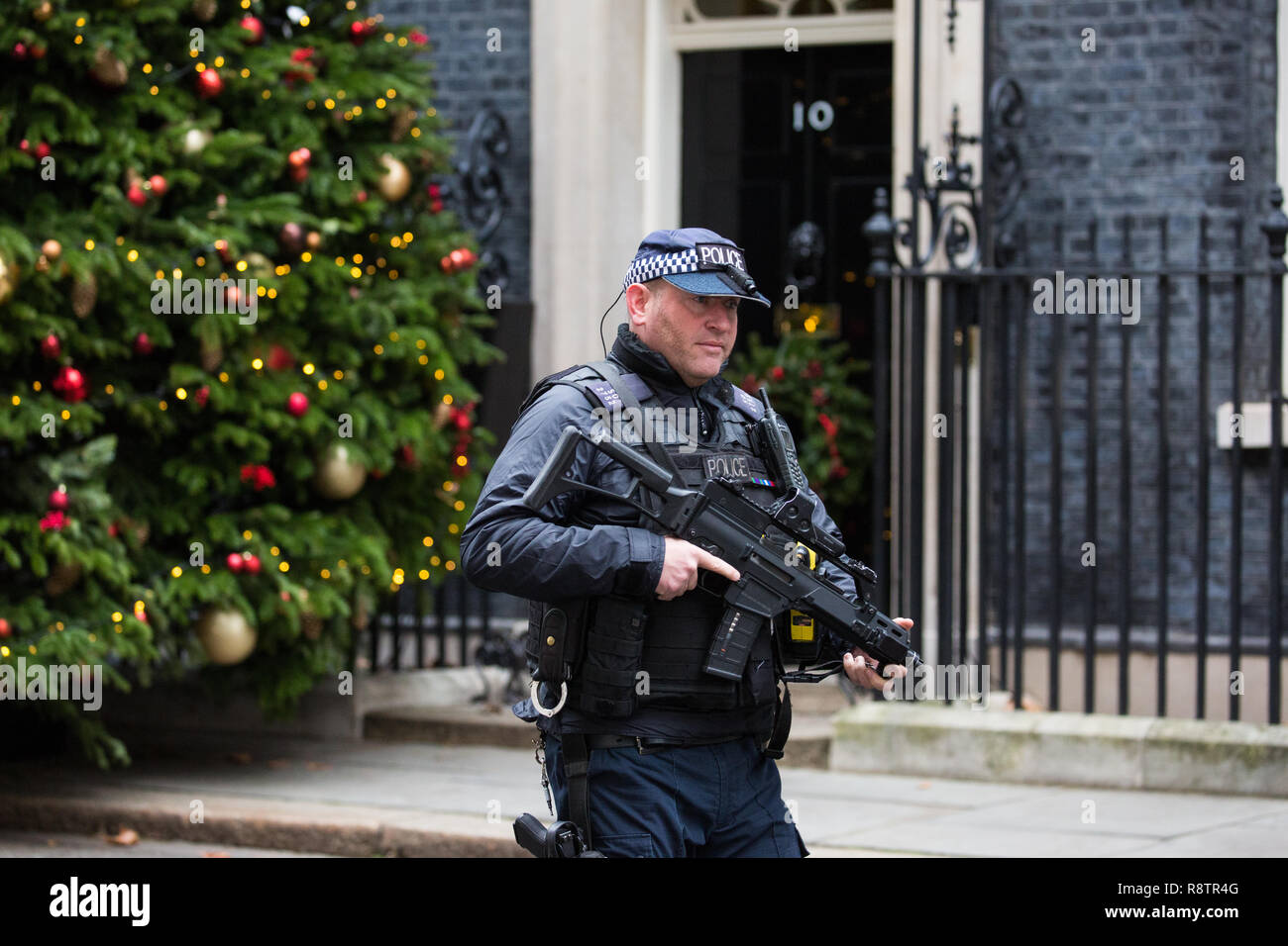London, UK. 18th December, 2018. An armed police officer passes in ...