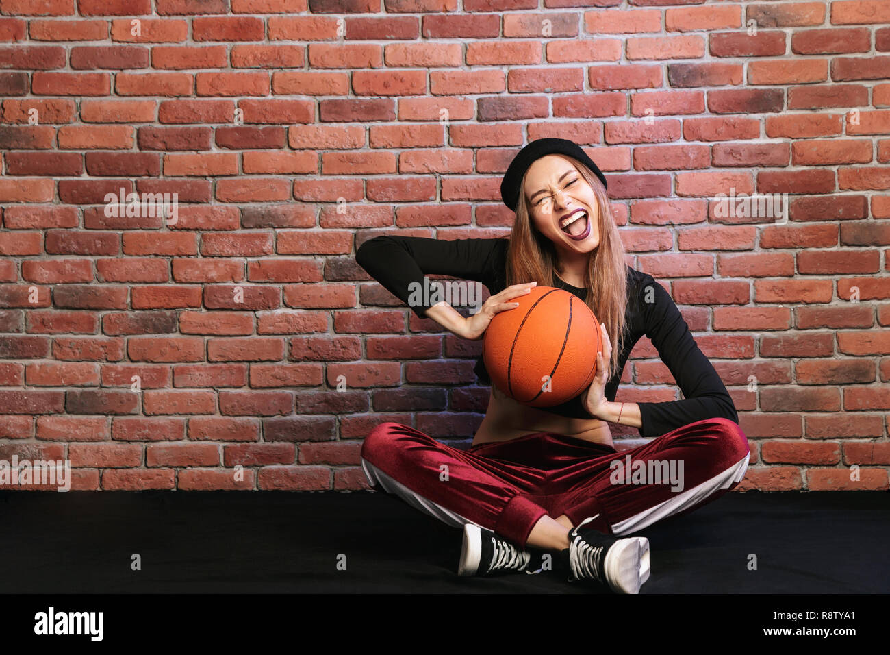 Girl sitting on basketball hi-res stock photography and images - Alamy