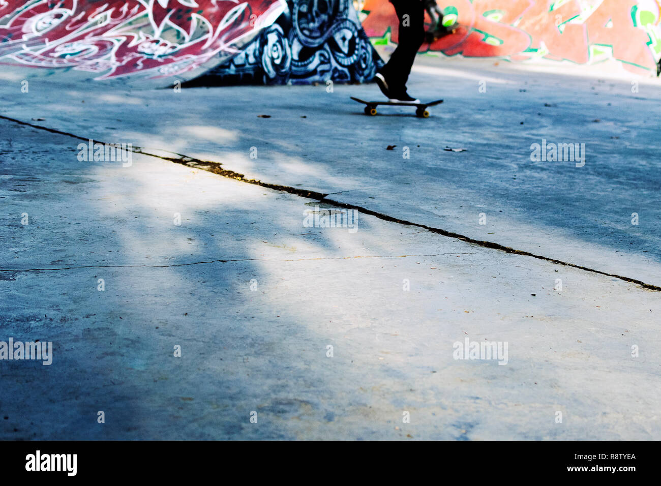 Young skateboarder skating inside of modern skatepark. Skateboard ...