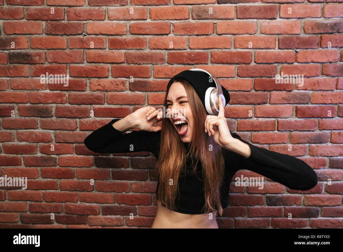 Image of beautiful hip hop woman 20s wearing headphones listening to ...