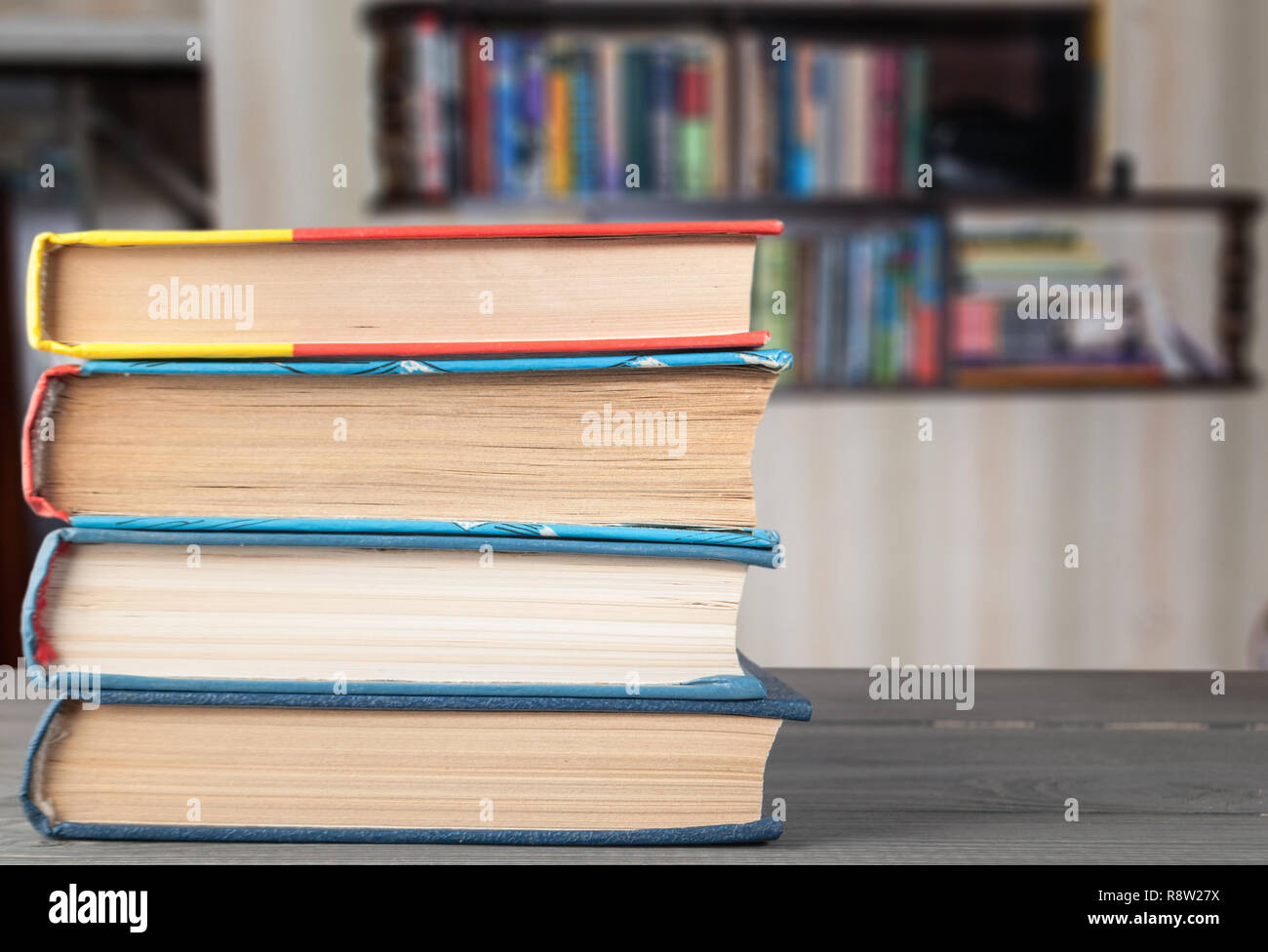 books on the table on the background of a bookshelf Stock Photo - Alamy
