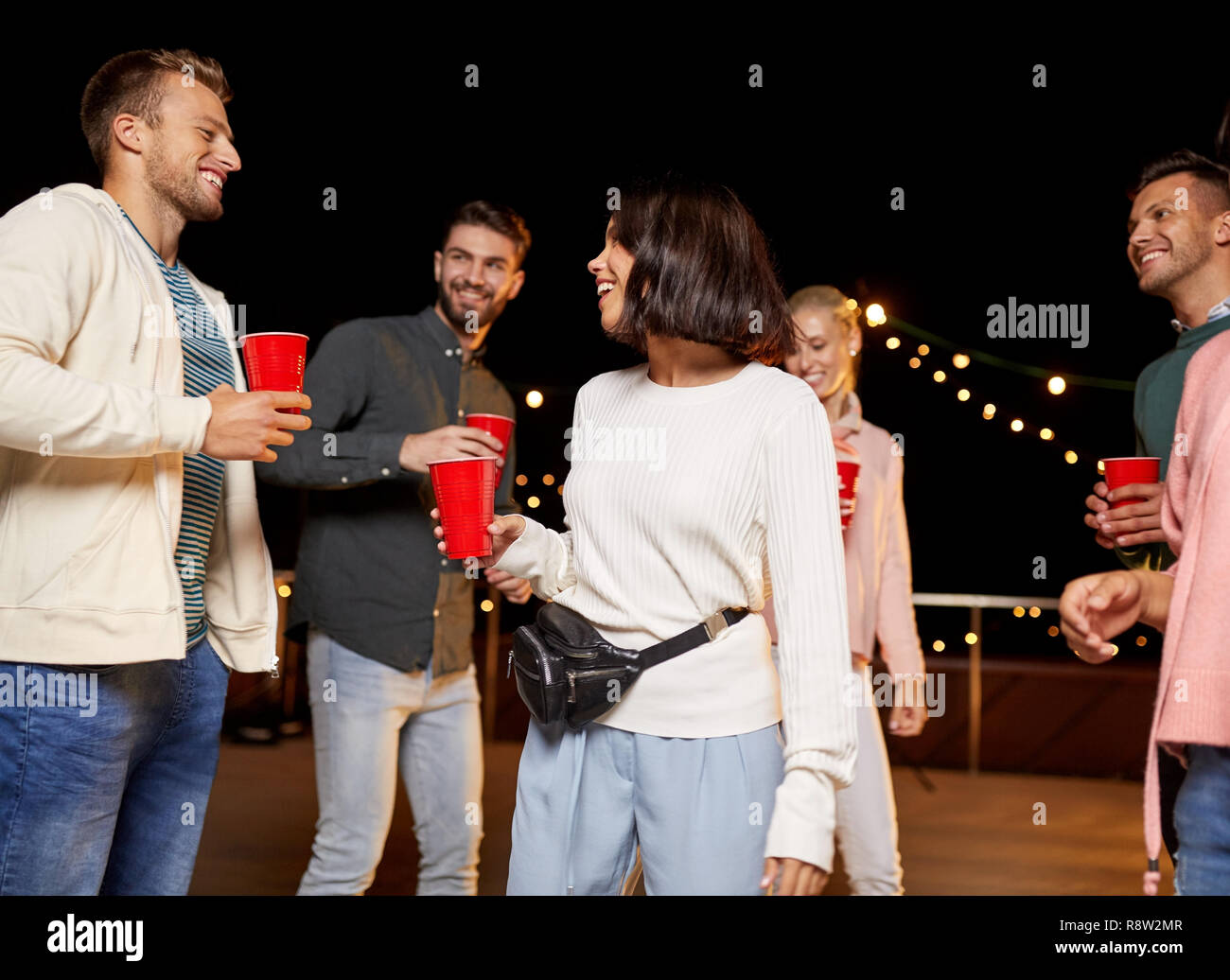 friends with drinks dancing at rooftop party Stock Photo - Alamy