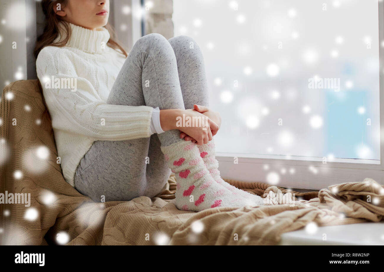 sad girl sitting on sill at home window in winter Stock Photo - Alamy