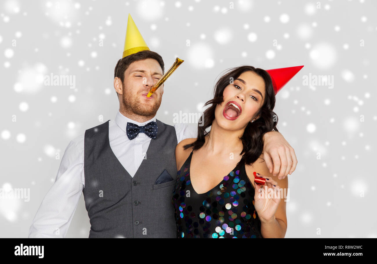 happy couple with party blowers having fun Stock Photo - Alamy