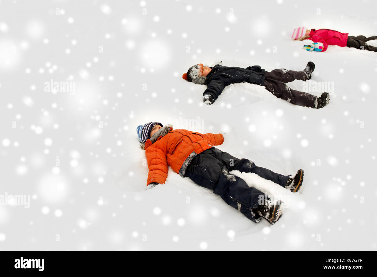happy little kids making snow angels in winter Stock Photo - Alamy