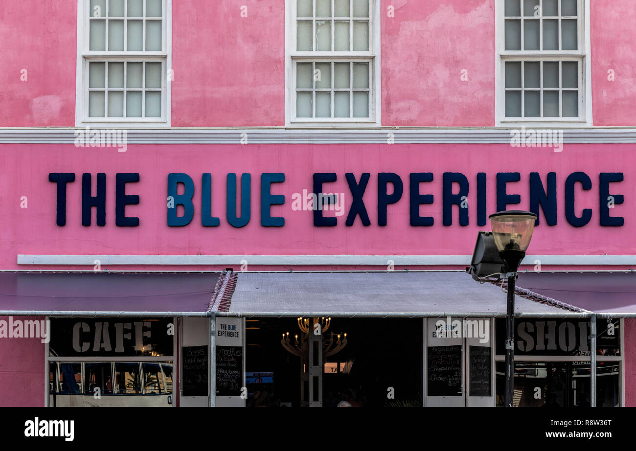 Sign for The Blue Experience cafe bar restaurant written on bright pink ...