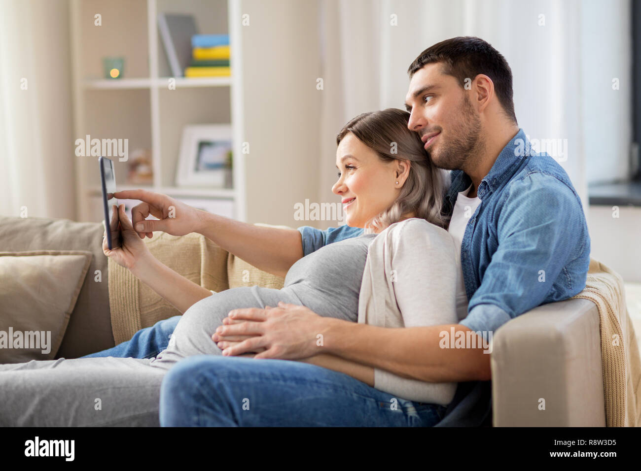 Happy pregnant couple tablet hi-res stock photography and images - Alamy