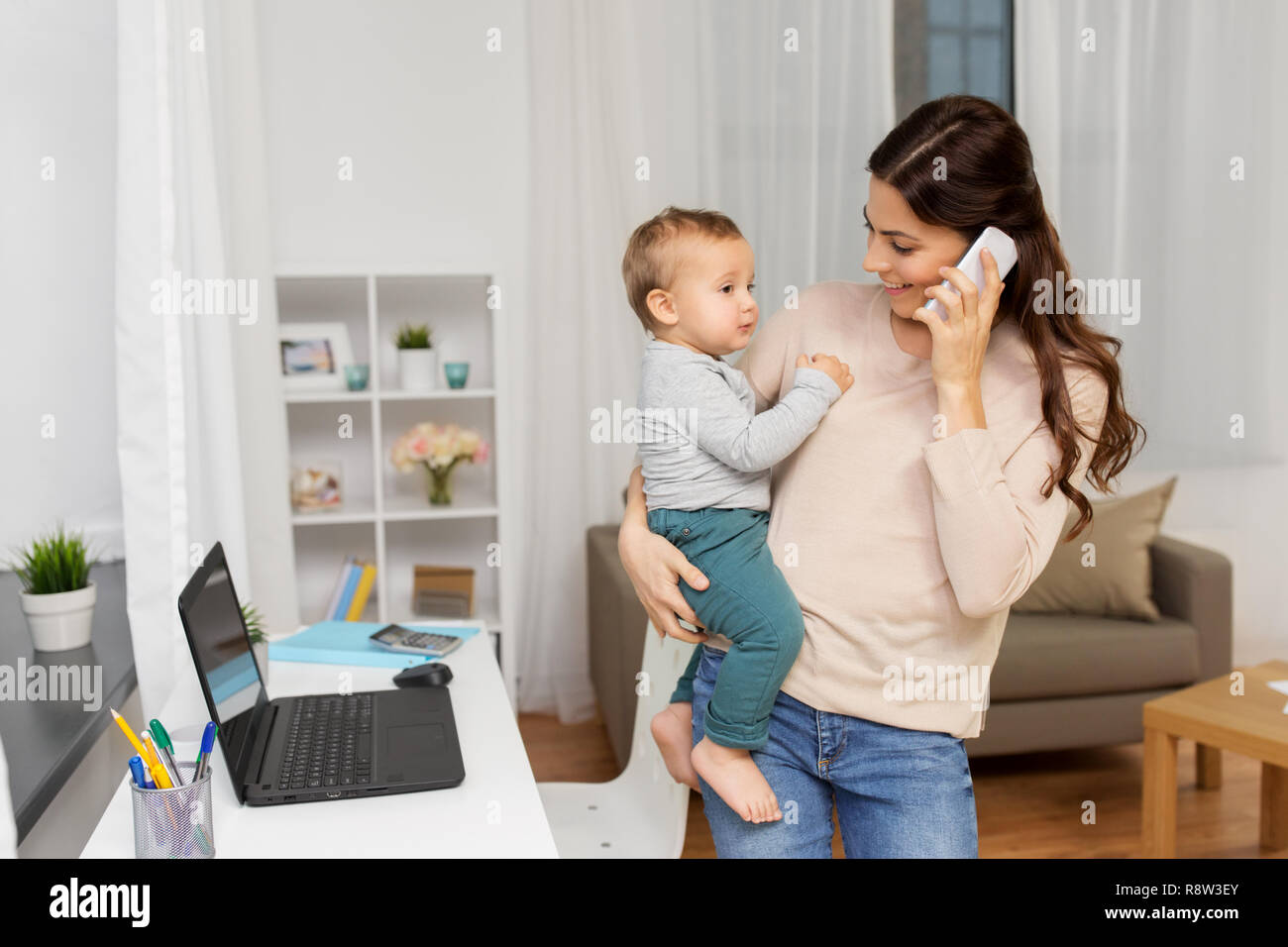 mother with baby calling on smartphone at home Stock Photo - Alamy