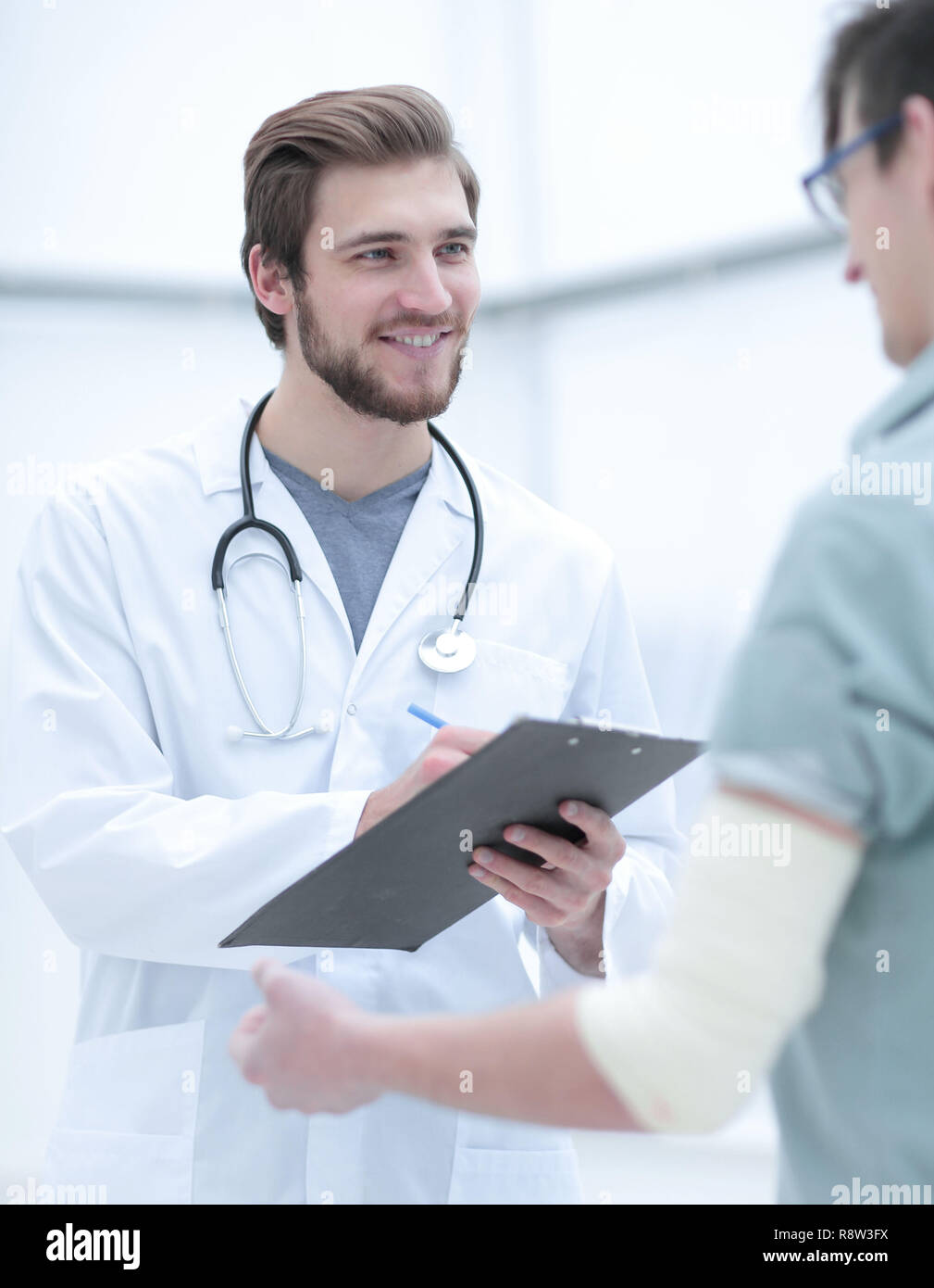podiatrist writing a prescription to her patient Stock Photo - Alamy