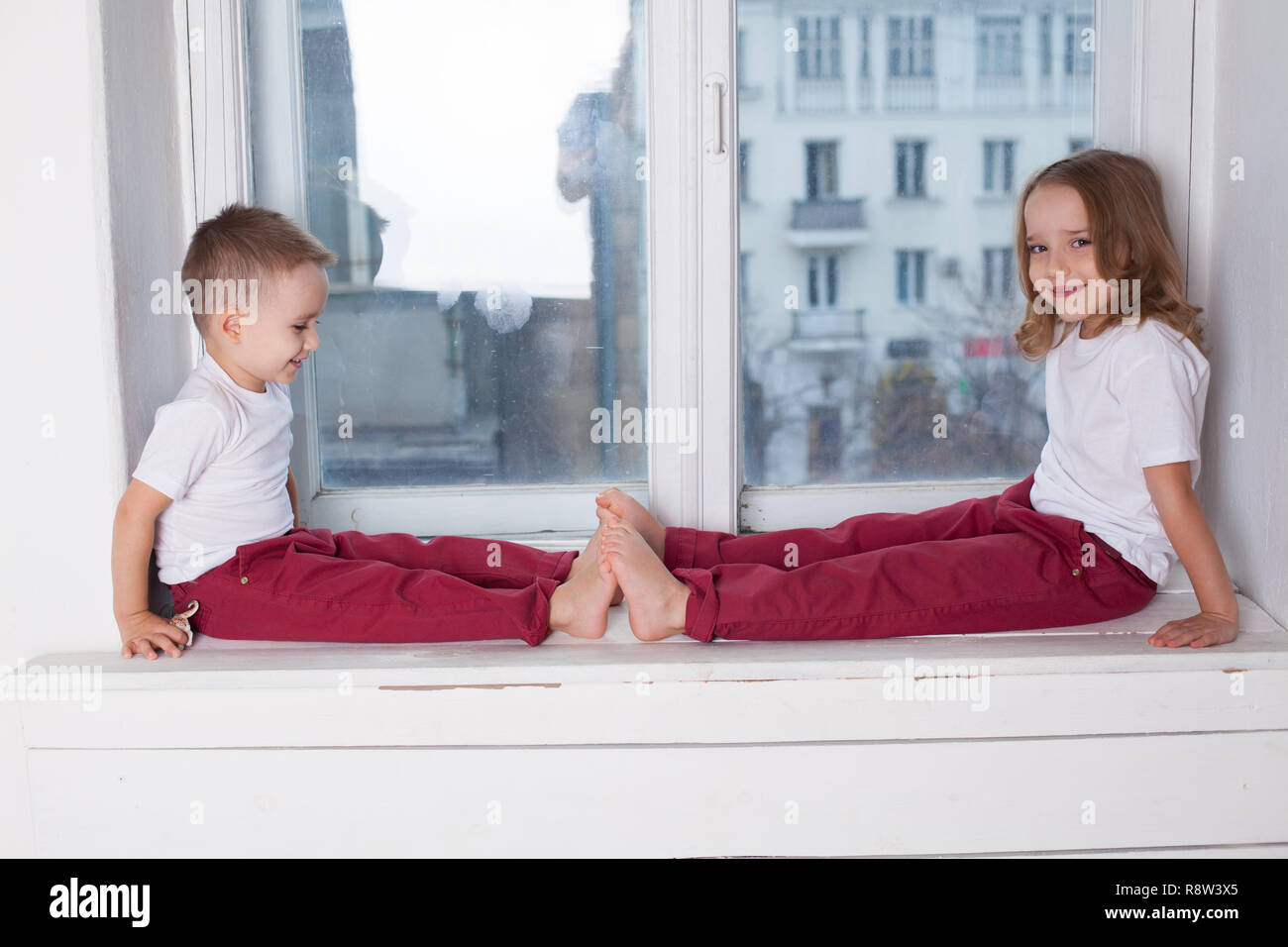 the little boy and girl alone at home watching in the window Stock ...