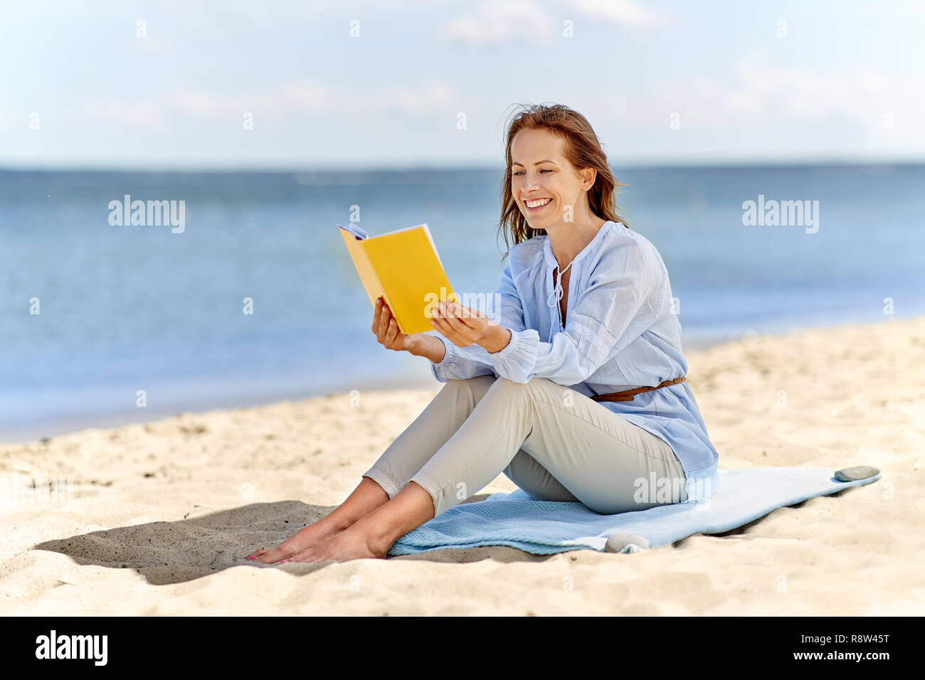 happy smiling woman reading book on summer beach Stock Photo - Alamy