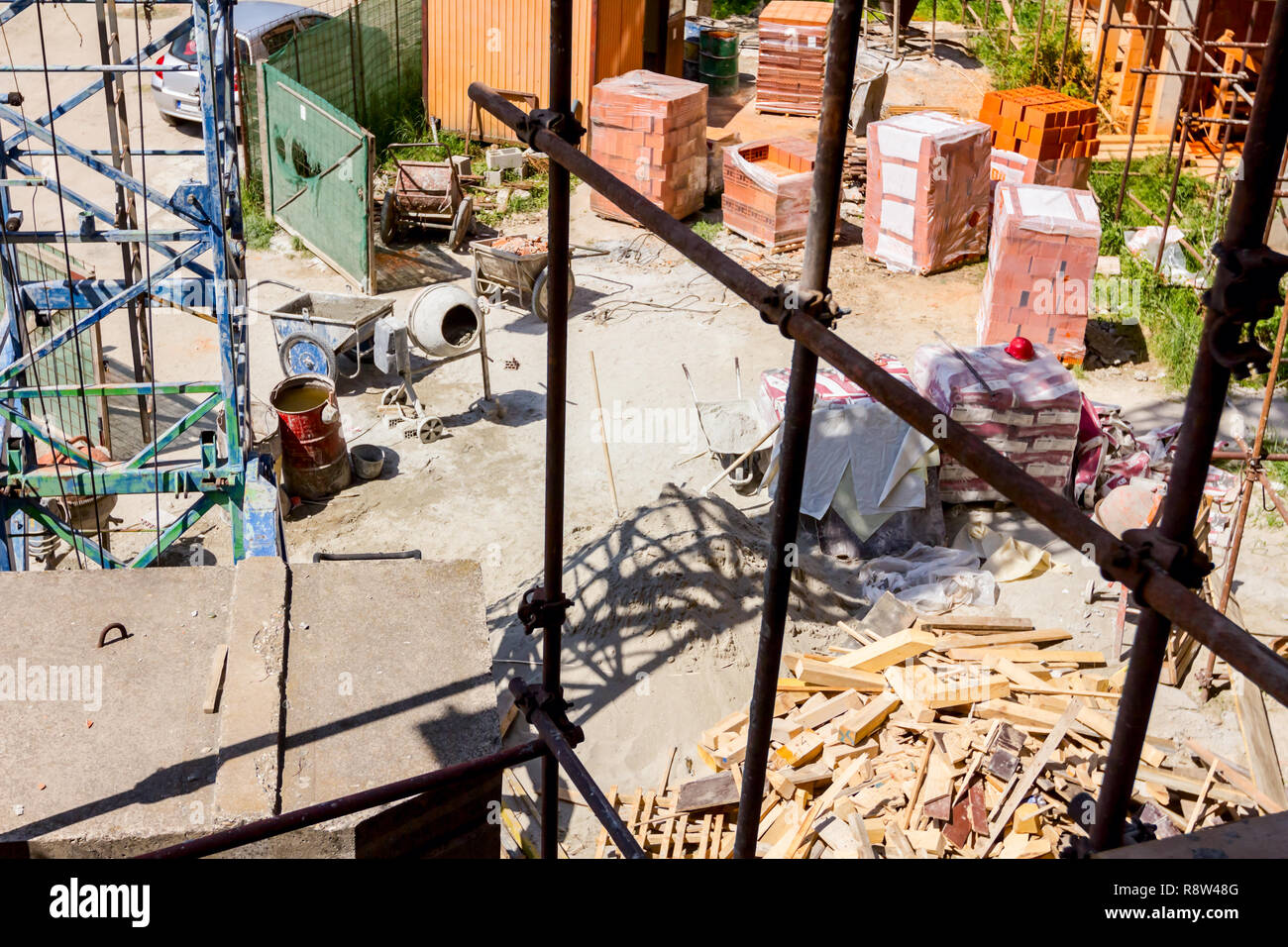 Above view on building site, scaffold, packed, piled resources and ...