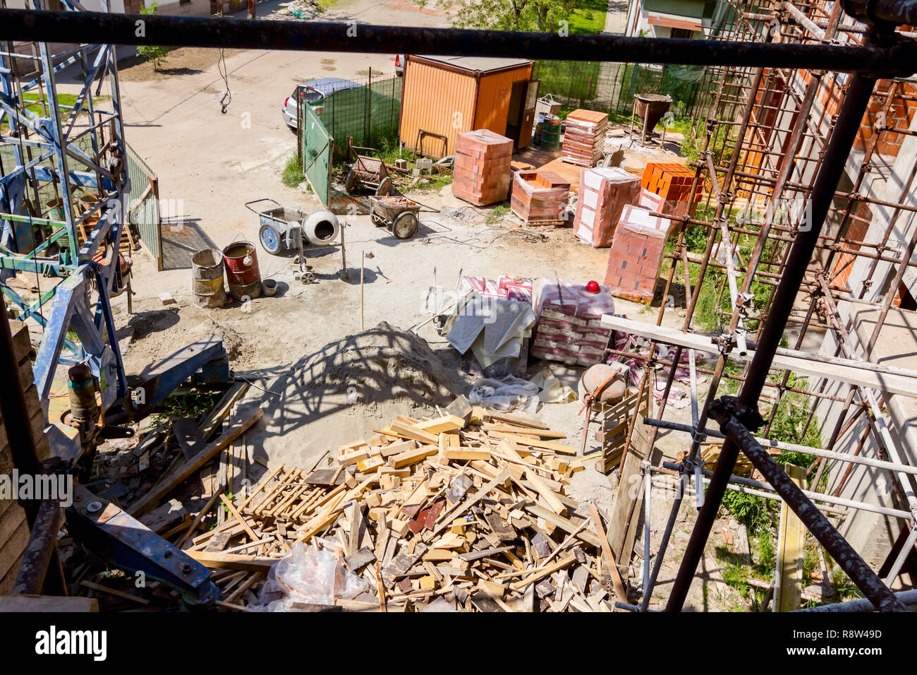 Above view on building site, scaffold, packed, piled resources and ...