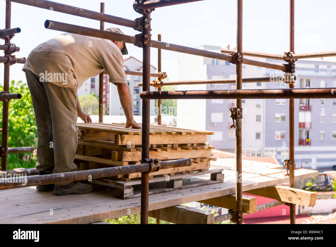 Operator, worker is arranging industrial pallets in pile for crane to ...