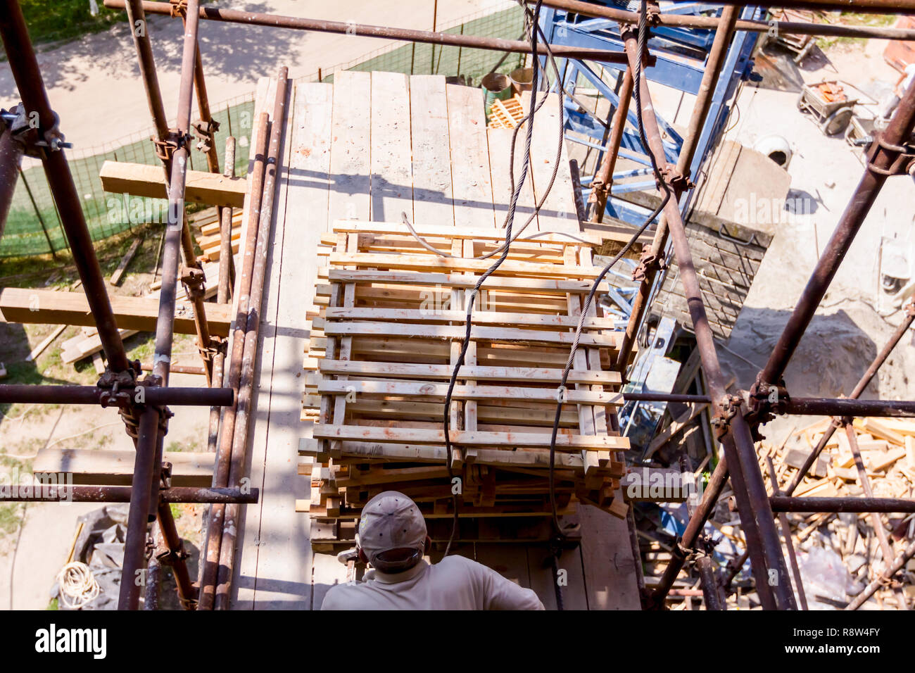Operator, worker is arranging industrial pallets in pile for crane to ...