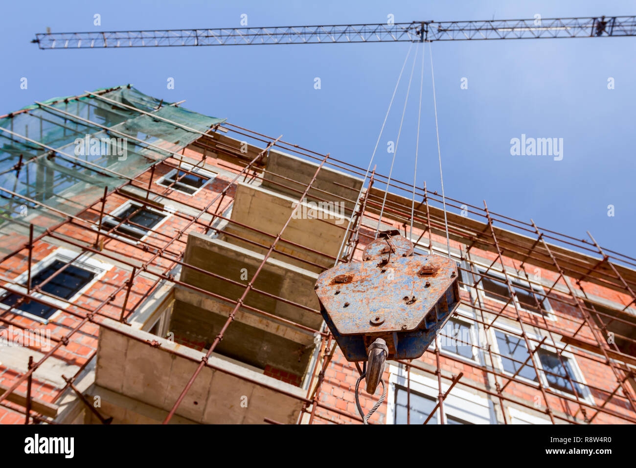 Crane hook is hanging, scaffold placed on unfinished building in ...