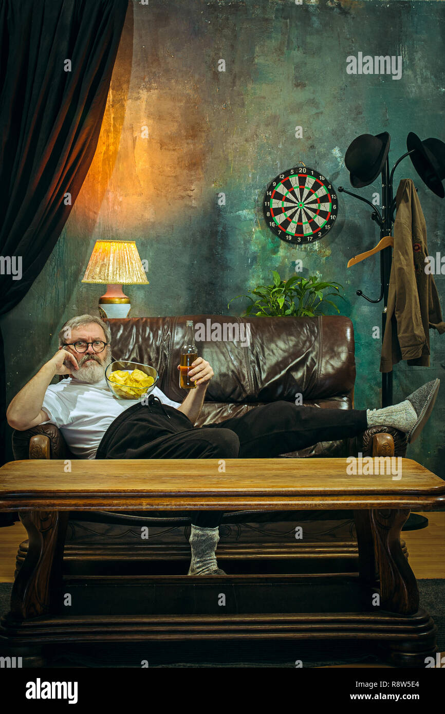 The crazy surprised football fan watching soccer game on television on ...