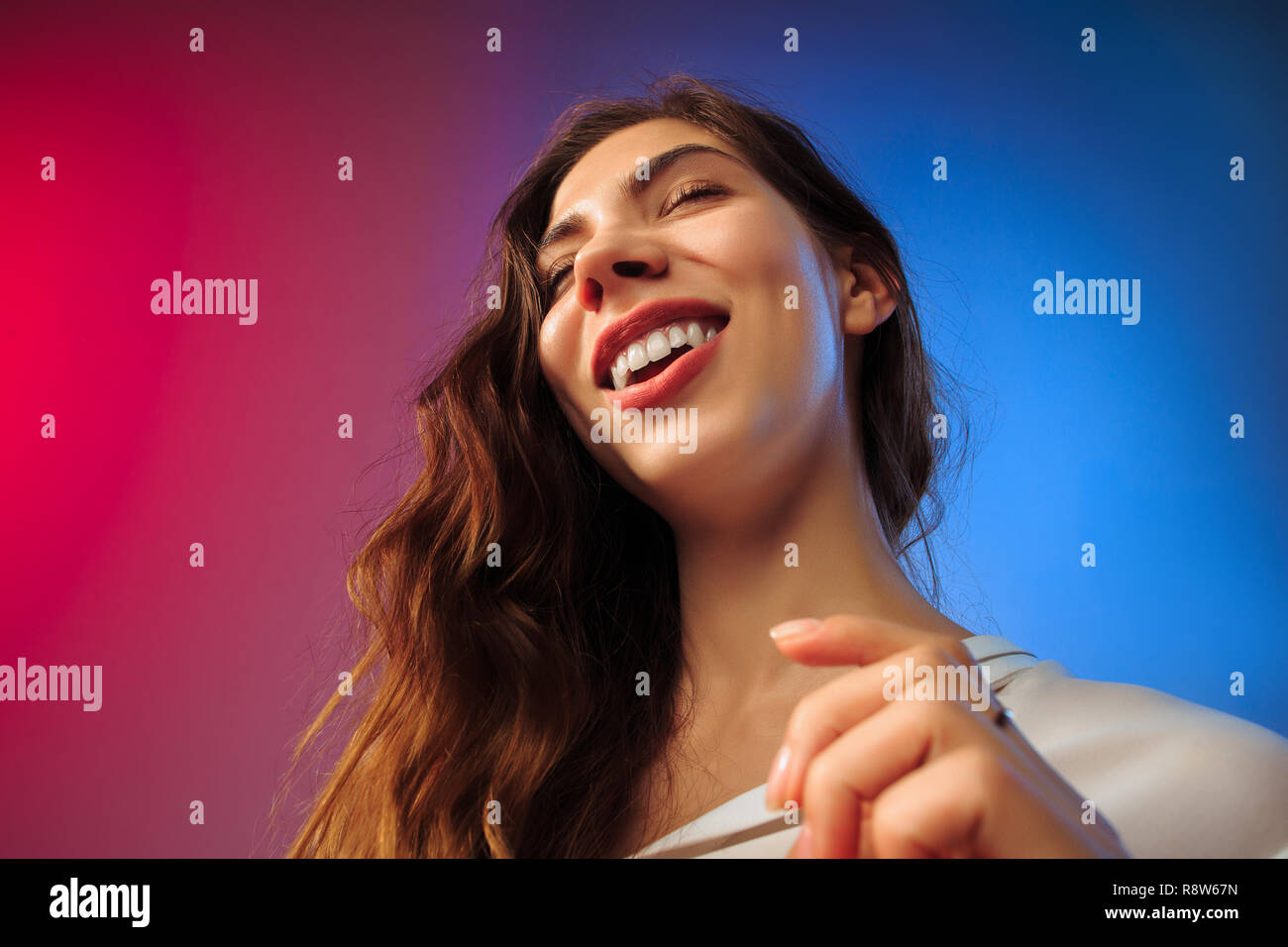 Happy woman standing, smiling on colored studio background. Beautiful ...