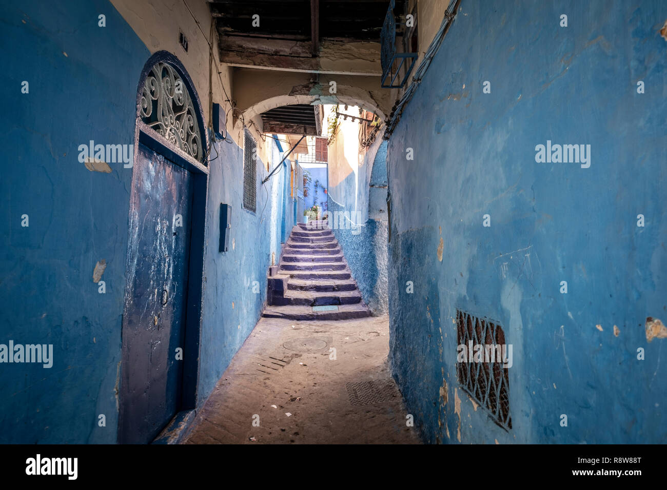 Ancient blue painted alley with old door entrance in the medina of ...