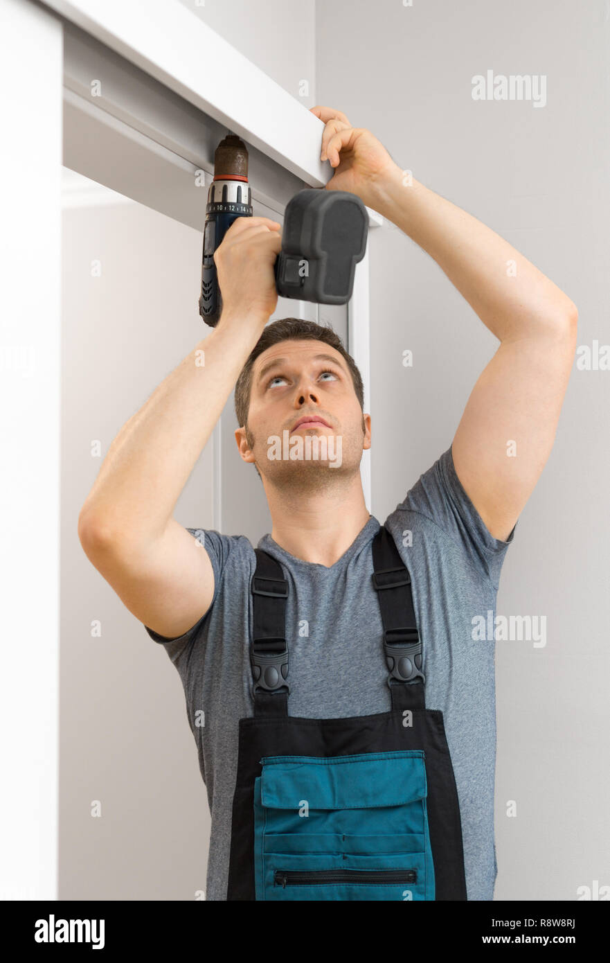 Handyman installing sliding door at home Stock Photo - Alamy